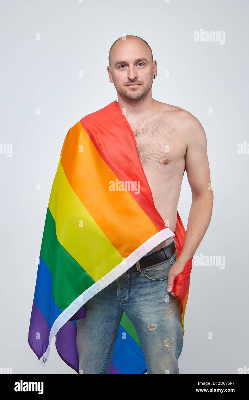 adult man poses with a rainbow flag. photo session in the Studio on a ...