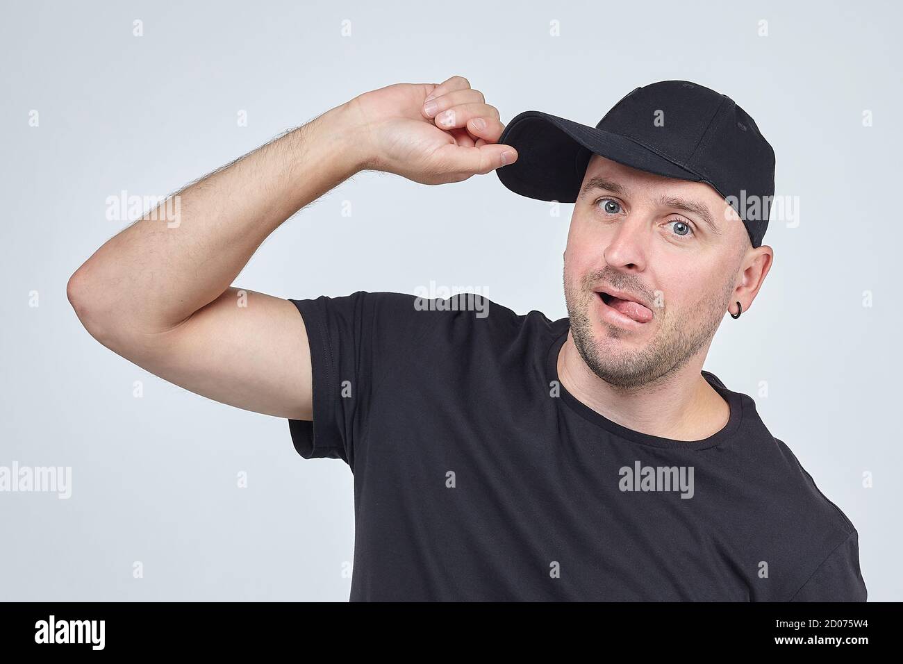 grown man in a black cap and t-shirt. photo session in the Studio on a ...