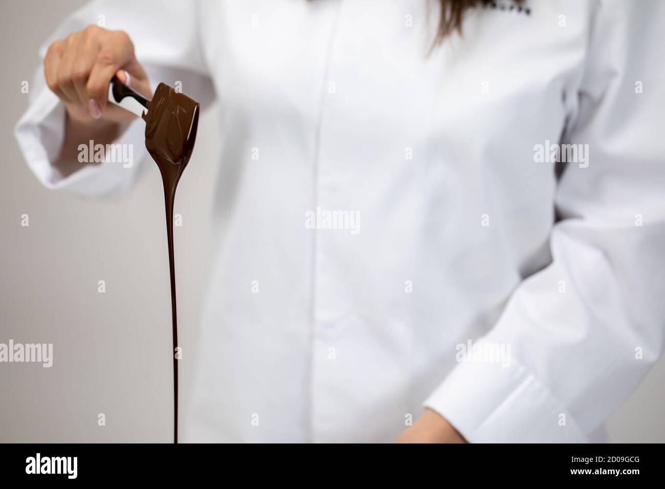 Melted hot chocolate pouring from spatula, chocolatier makes Belgian ...