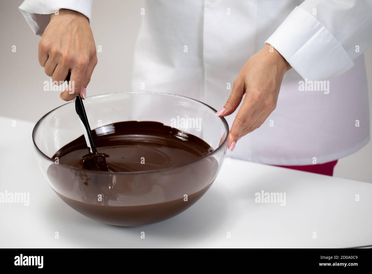 Close up mixing melted chocolate, making hand-crafted chocolate candies ...