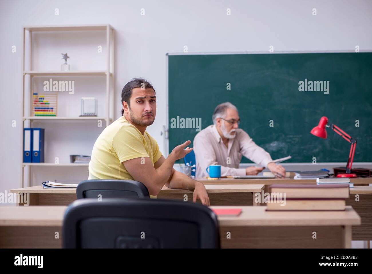 Old teacher and young student in the classroom Stock Photo - Alamy