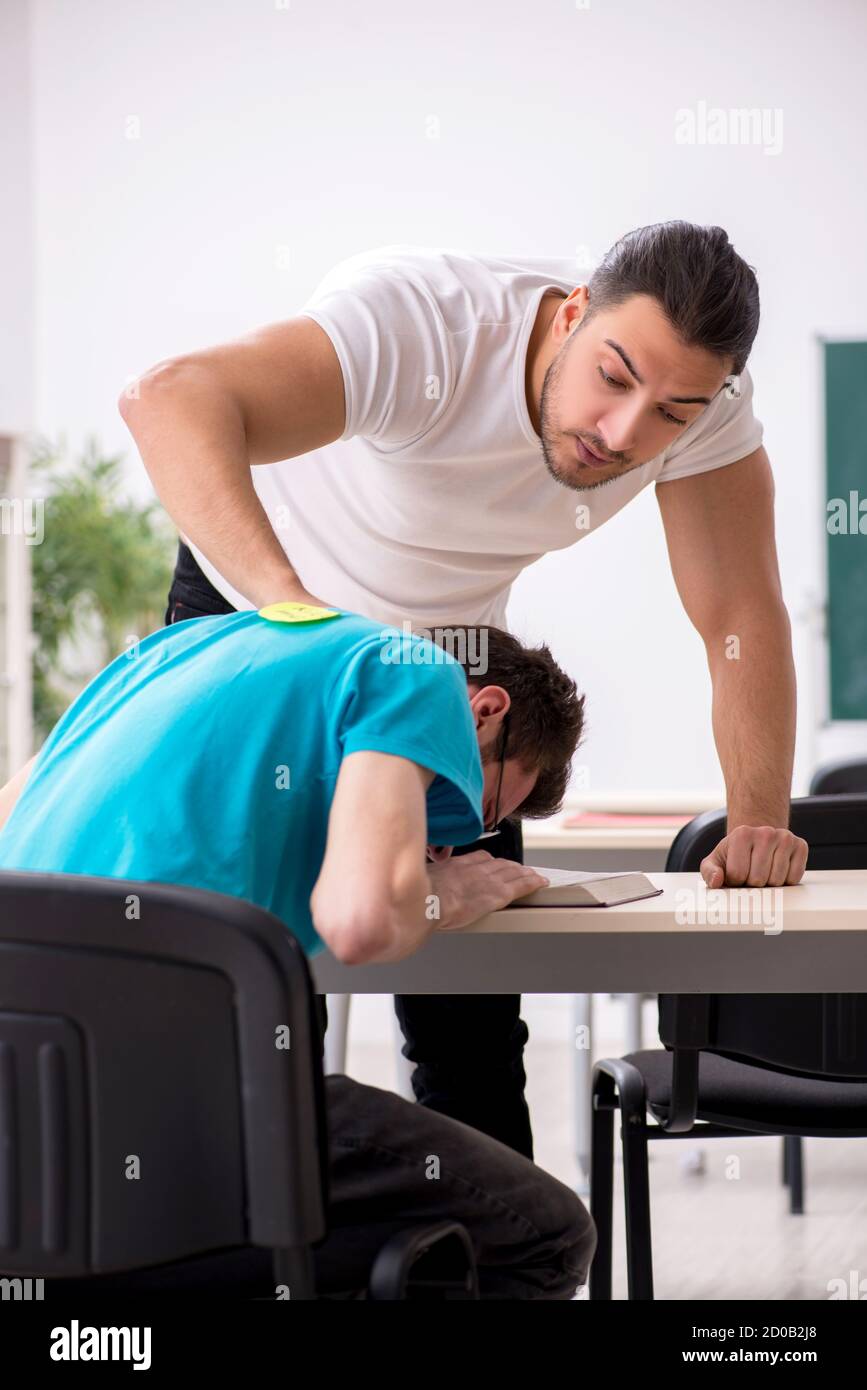 Male pupils in bullying concept in the classroom Stock Photo - Alamy