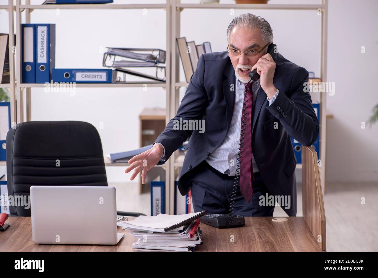 Old employee unhappy with excessive work Stock Photo - Alamy
