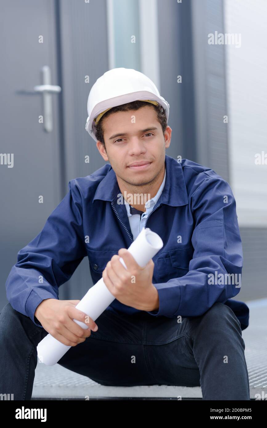 engineer at a construction holding drawings Stock Photo - Alamy