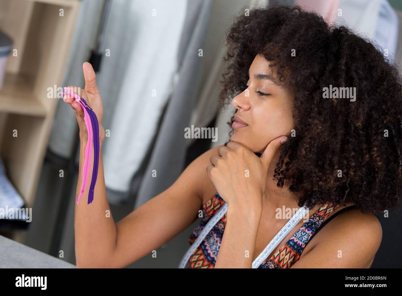 dressmaker comparing two different coloured zips Stock Photo - Alamy