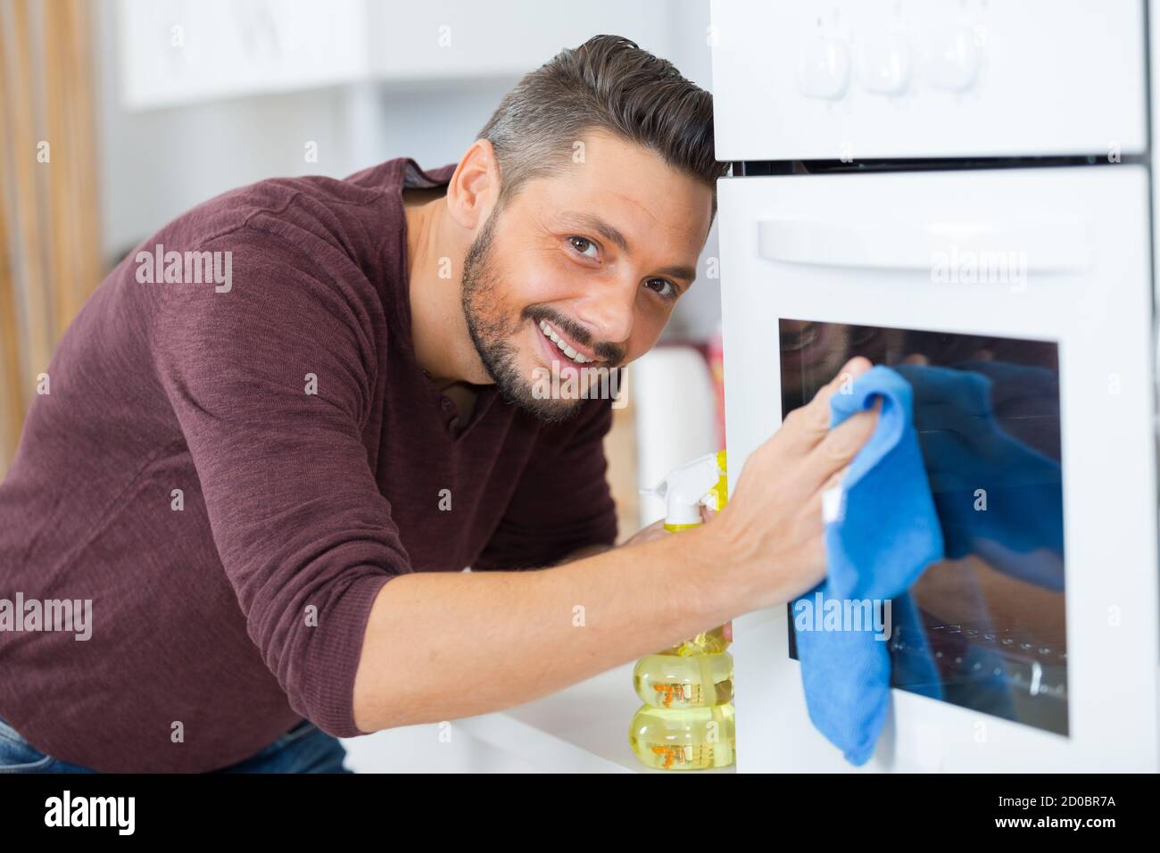 man cleaning domestic oven in kitchen Stock Photo - Alamy