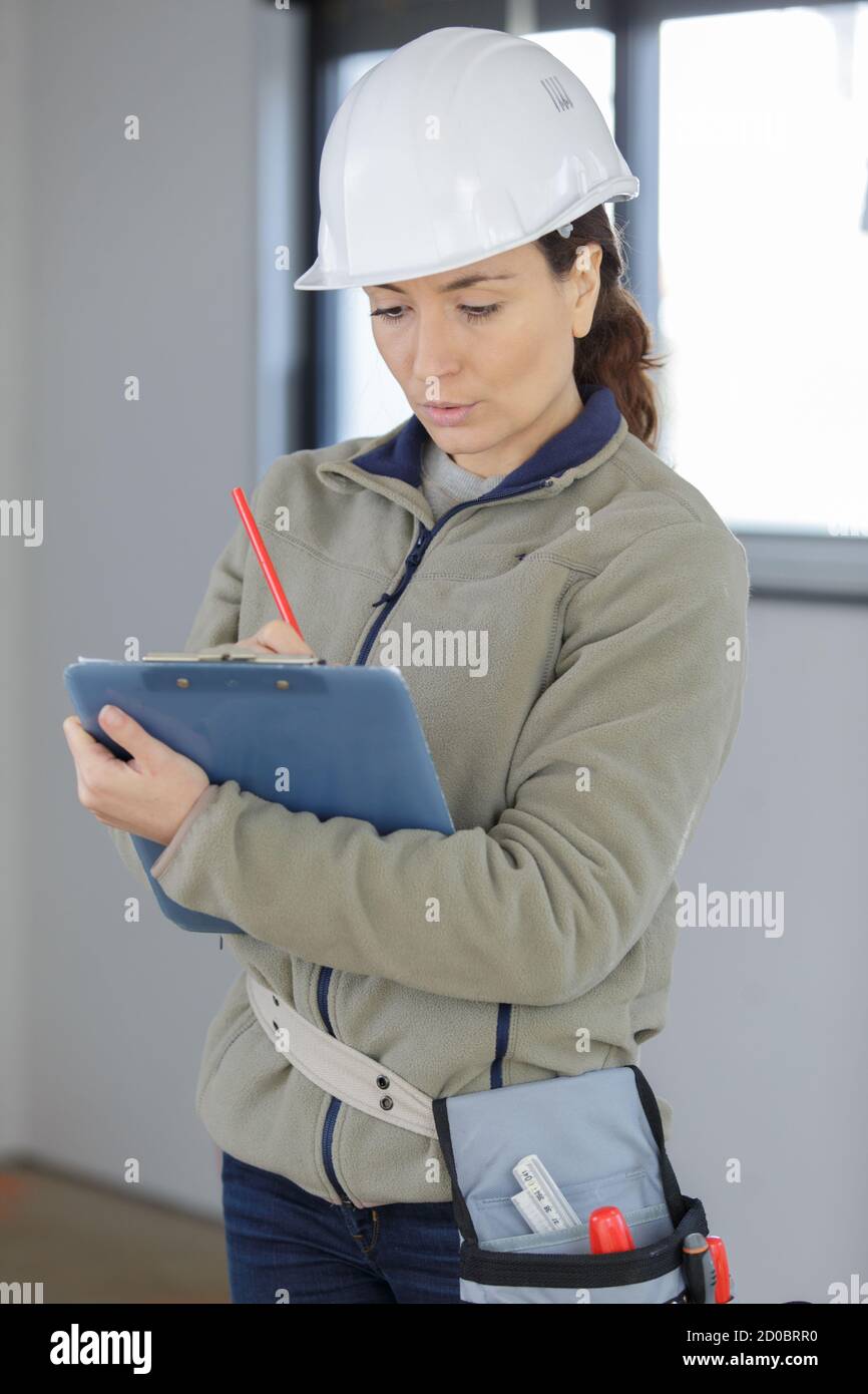 female manual worker making notes on a clipboard Stock Photo - Alamy