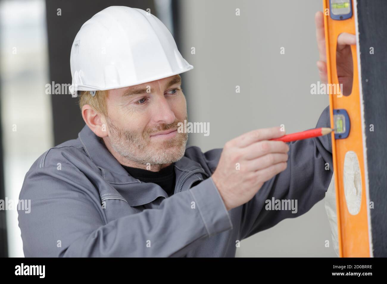 a builder measuring wall vertically Stock Photo - Alamy