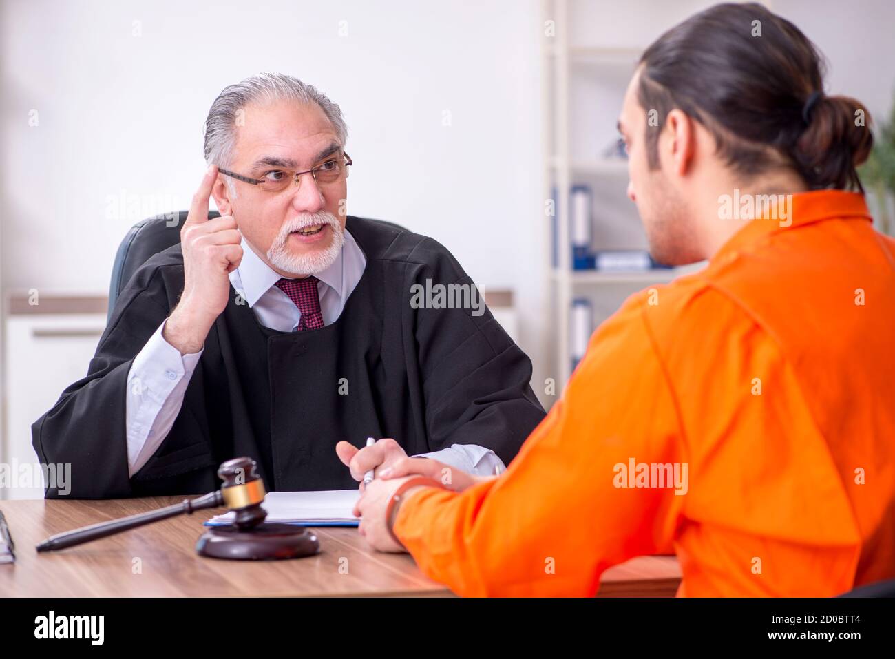 Old judge meeting with young captive in courthouse Stock Photo - Alamy