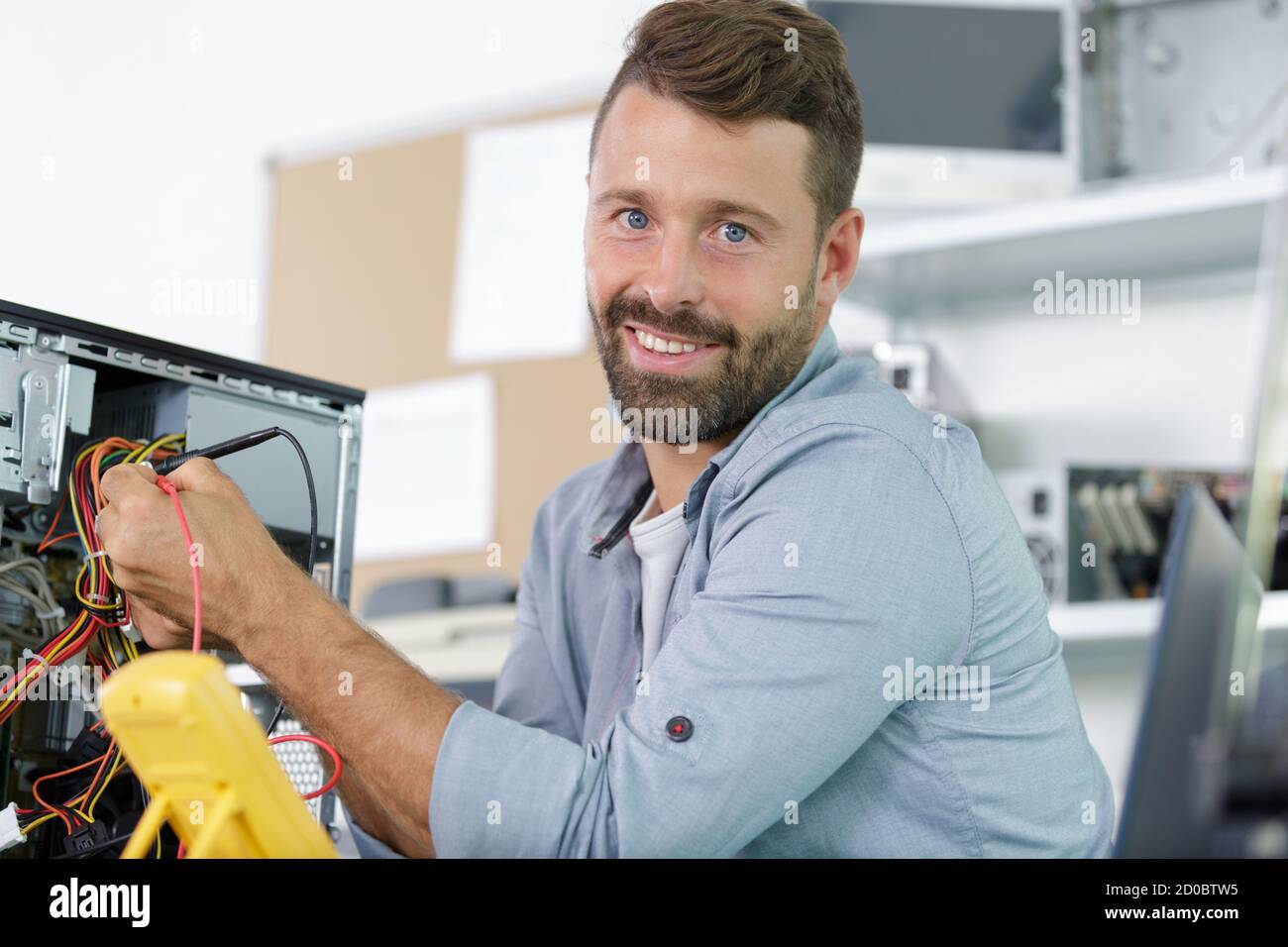 a happy man fixing a computer Stock Photo - Alamy
