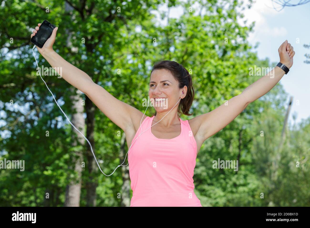 woman out exercising holding her arms raised Stock Photo - Alamy