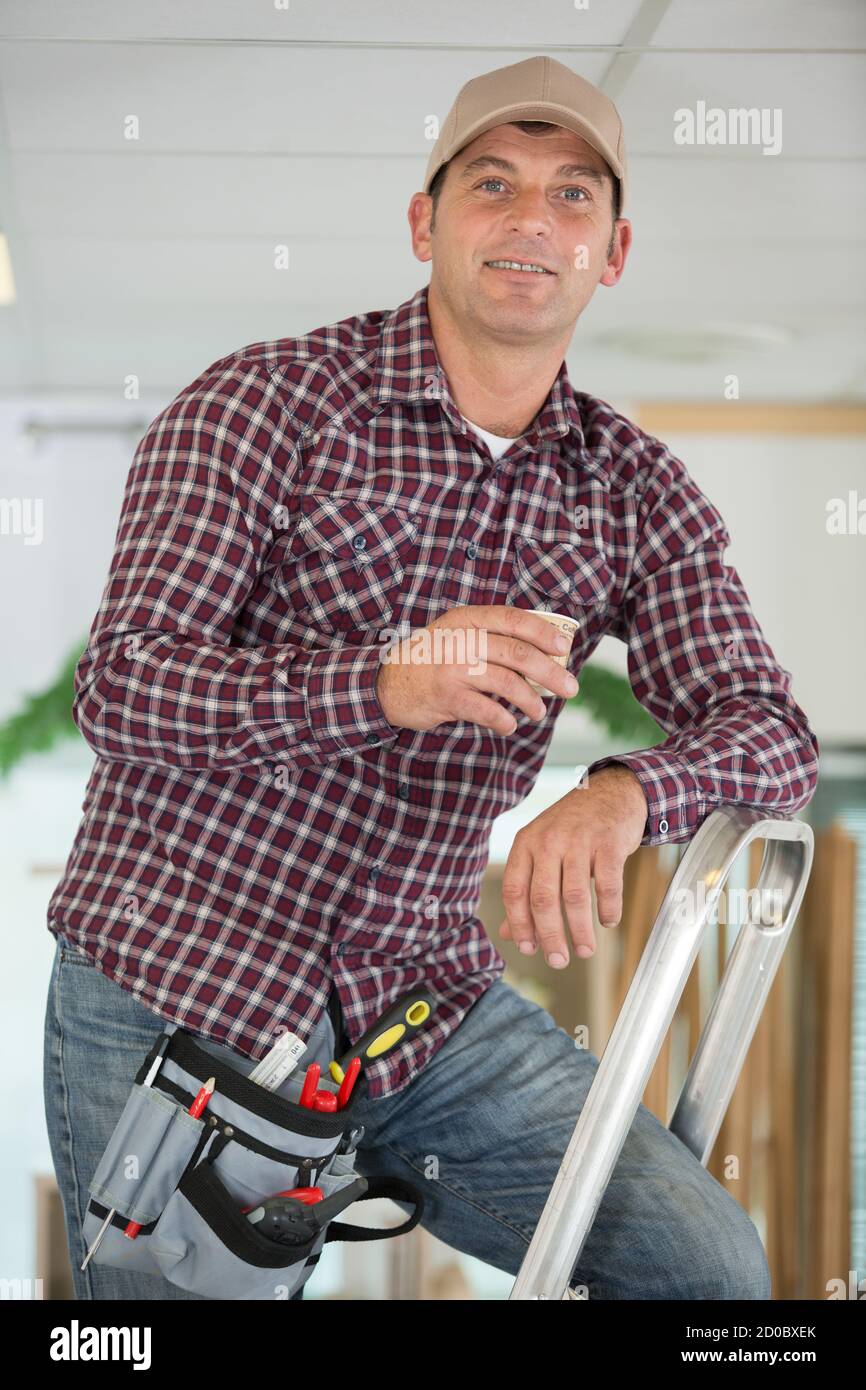 smile man posing near ladder Stock Photo - Alamy