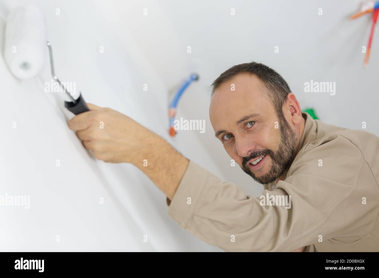 man painting wall with paint Stock Photo - Alamy