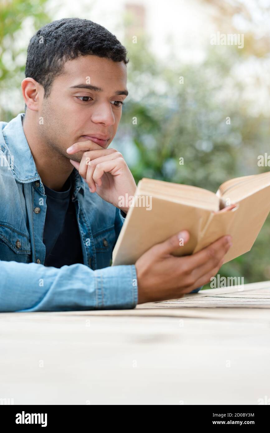 young student reading book outdoors Stock Photo - Alamy