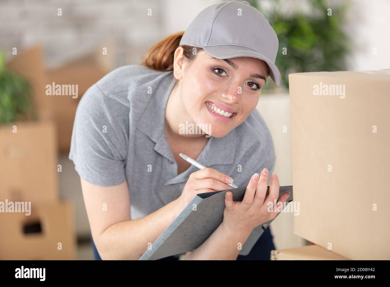 delivery person delivering packages holding clipboard Stock Photo - Alamy