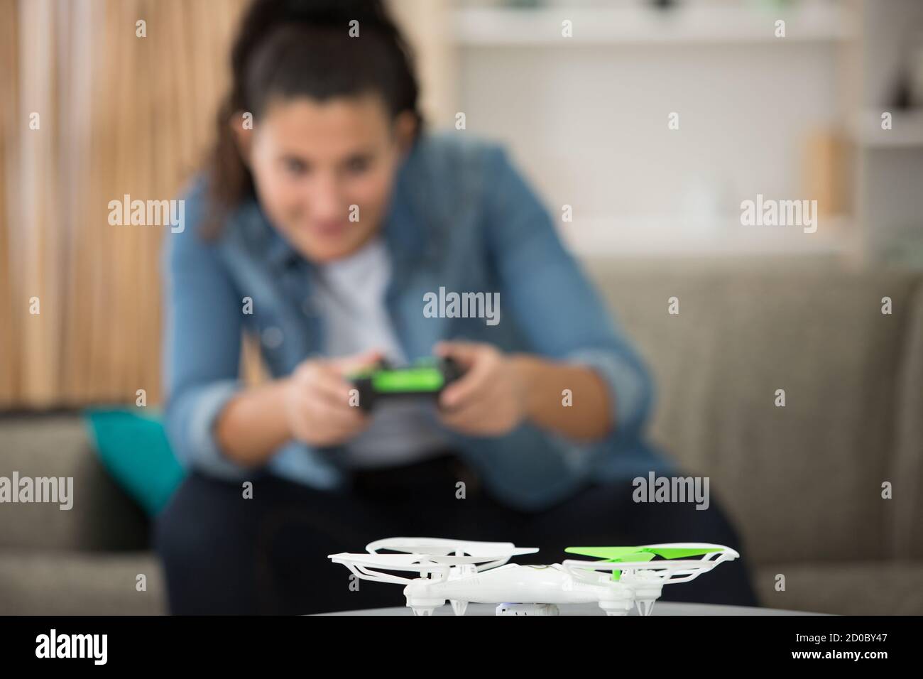 young woman operating a drone indoors Stock Photo - Alamy
