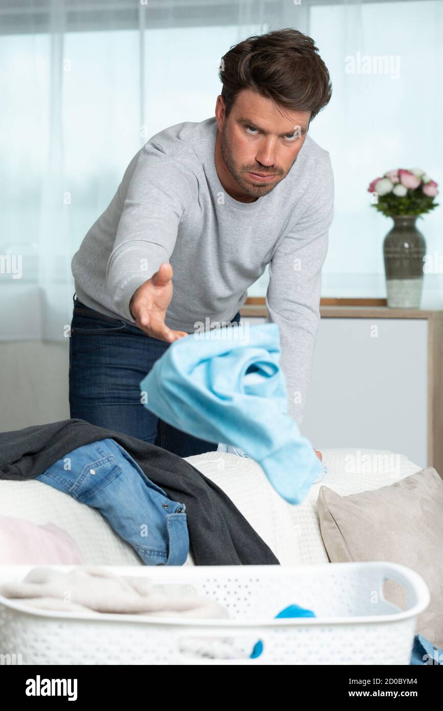 upset man is doing the laundry Stock Photo - Alamy
