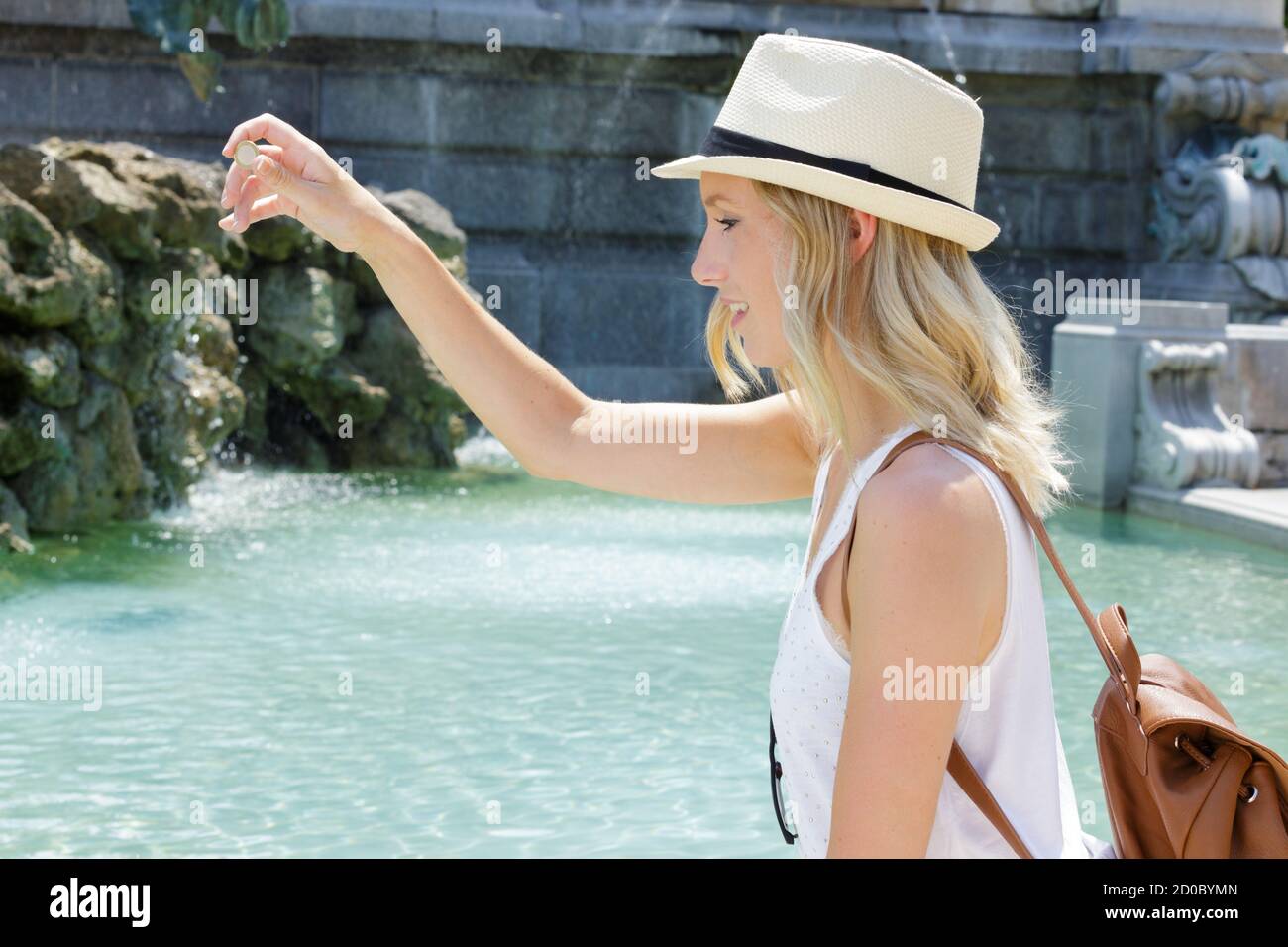 female tourist throwing coin in the water at trevi fountain Stock Photo ...
