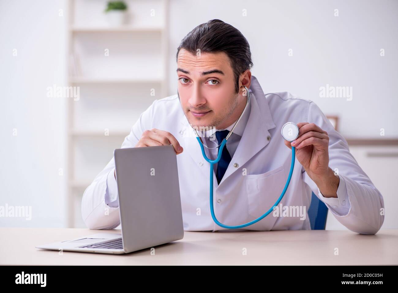 Young doctor with stethoscope repairing computer Stock Photo - Alamy