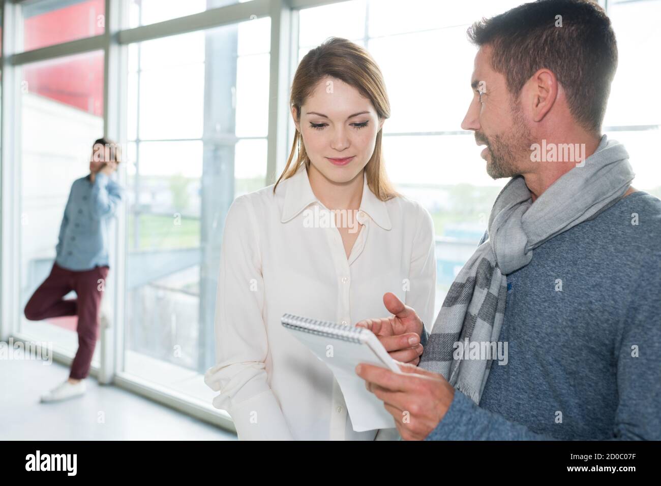 man and woman looking at notebook in sunny corridor Stock Photo - Alamy