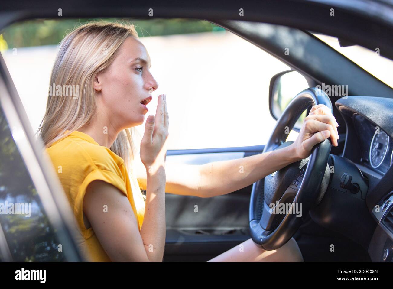 tired woman yawning inside car Stock Photo - Alamy