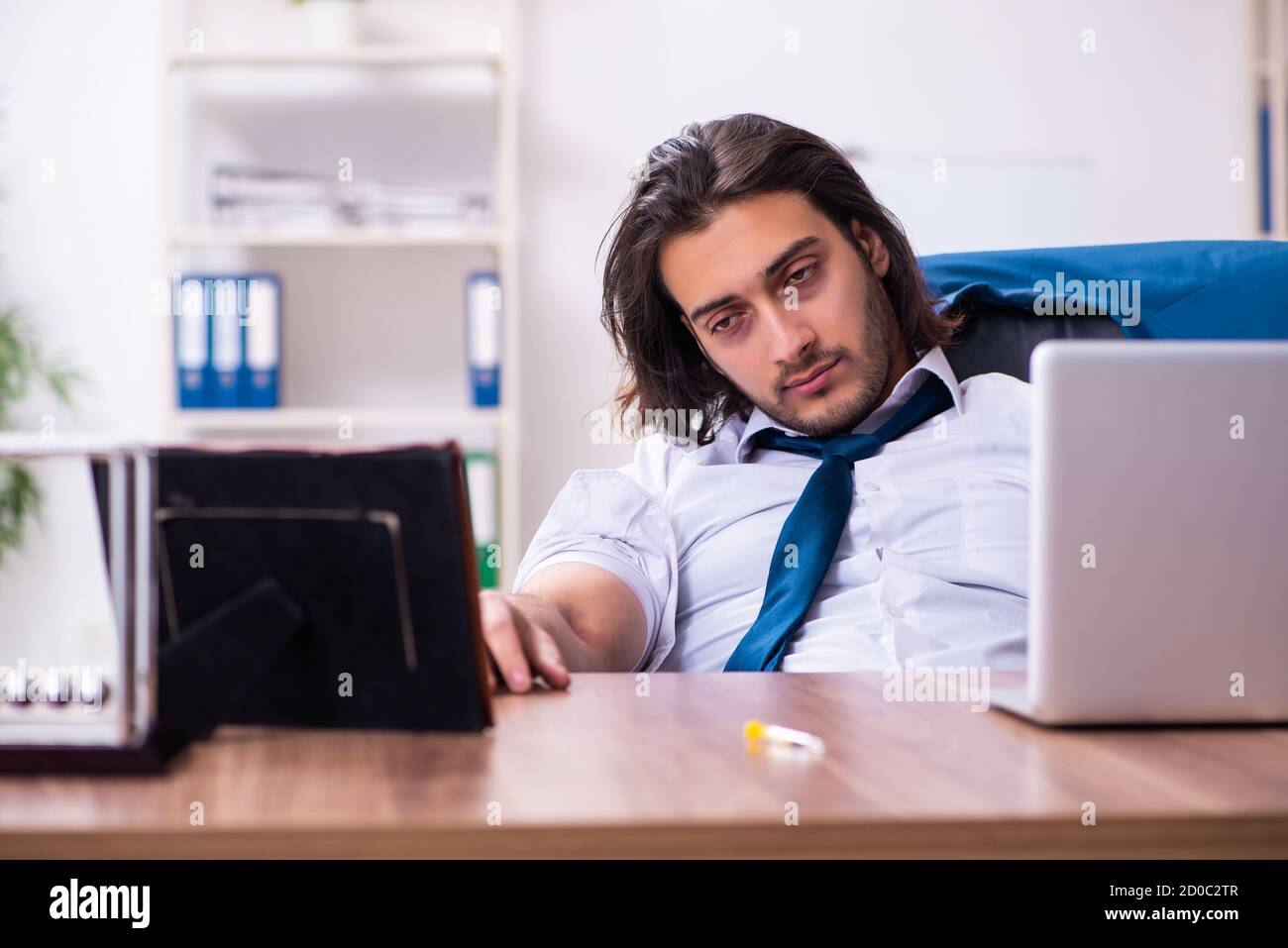 Drug addicted employee working in the office Stock Photo - Alamy