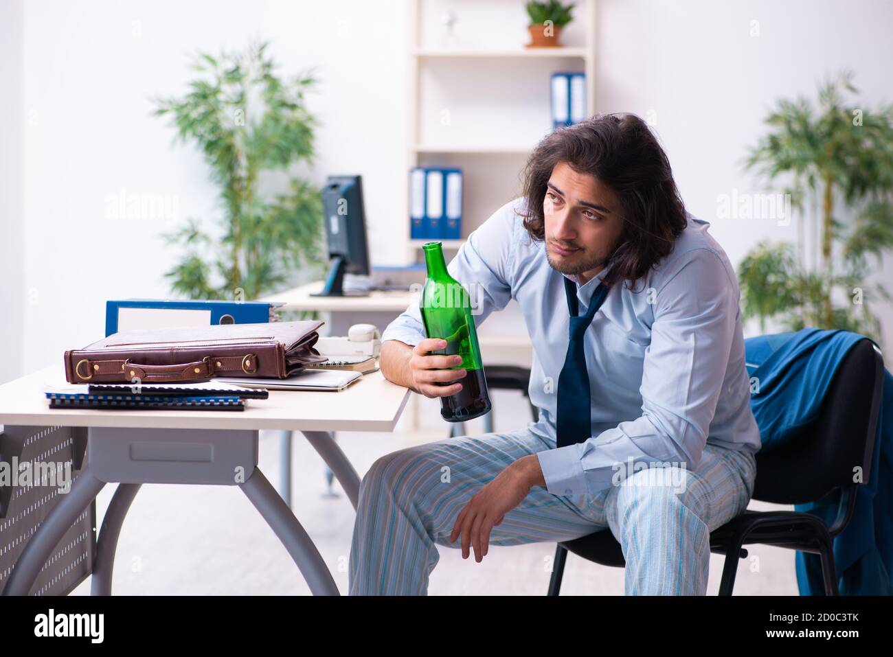 Male employee coming to work after the party Stock Photo - Alamy