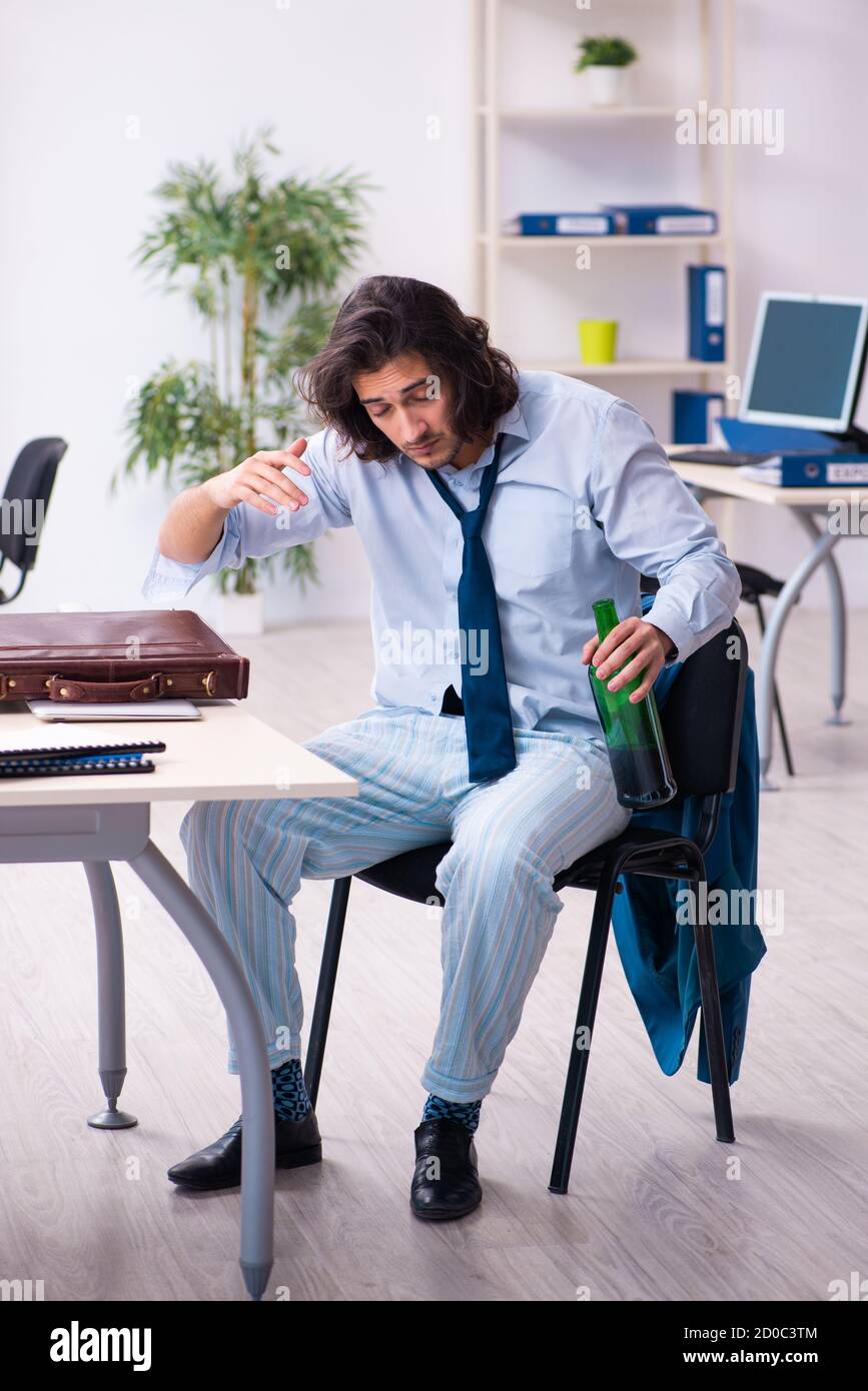 Male employee coming to work after the party Stock Photo - Alamy
