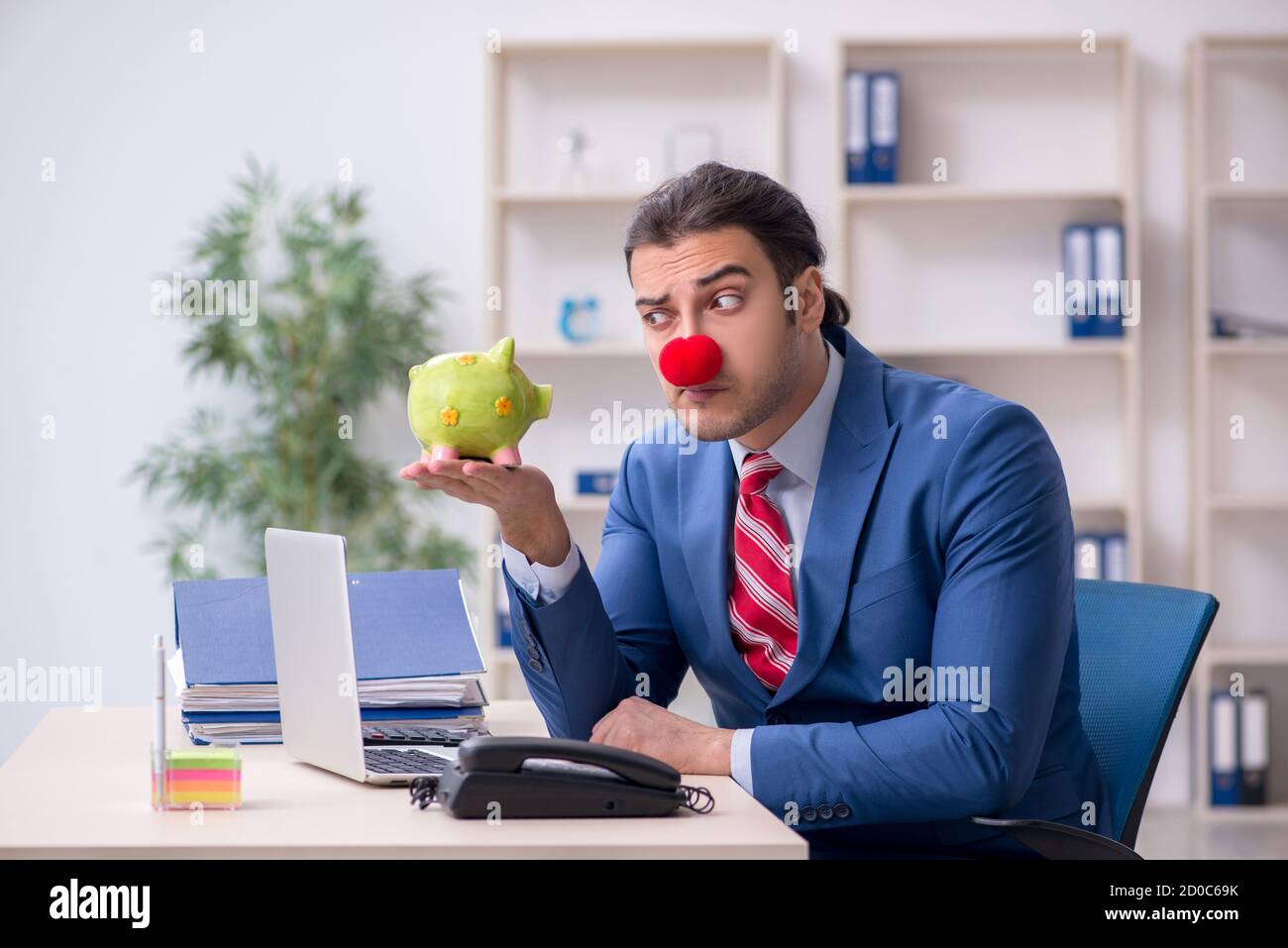 Funny employee clown working in the office room Stock Photo - Alamy