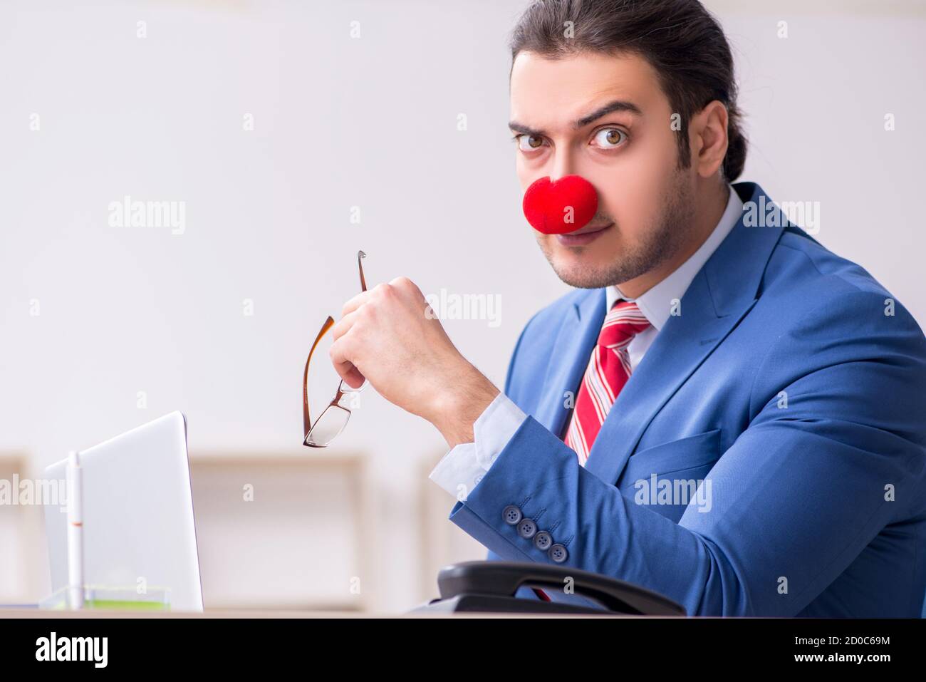 Funny employee clown working in the office room Stock Photo - Alamy
