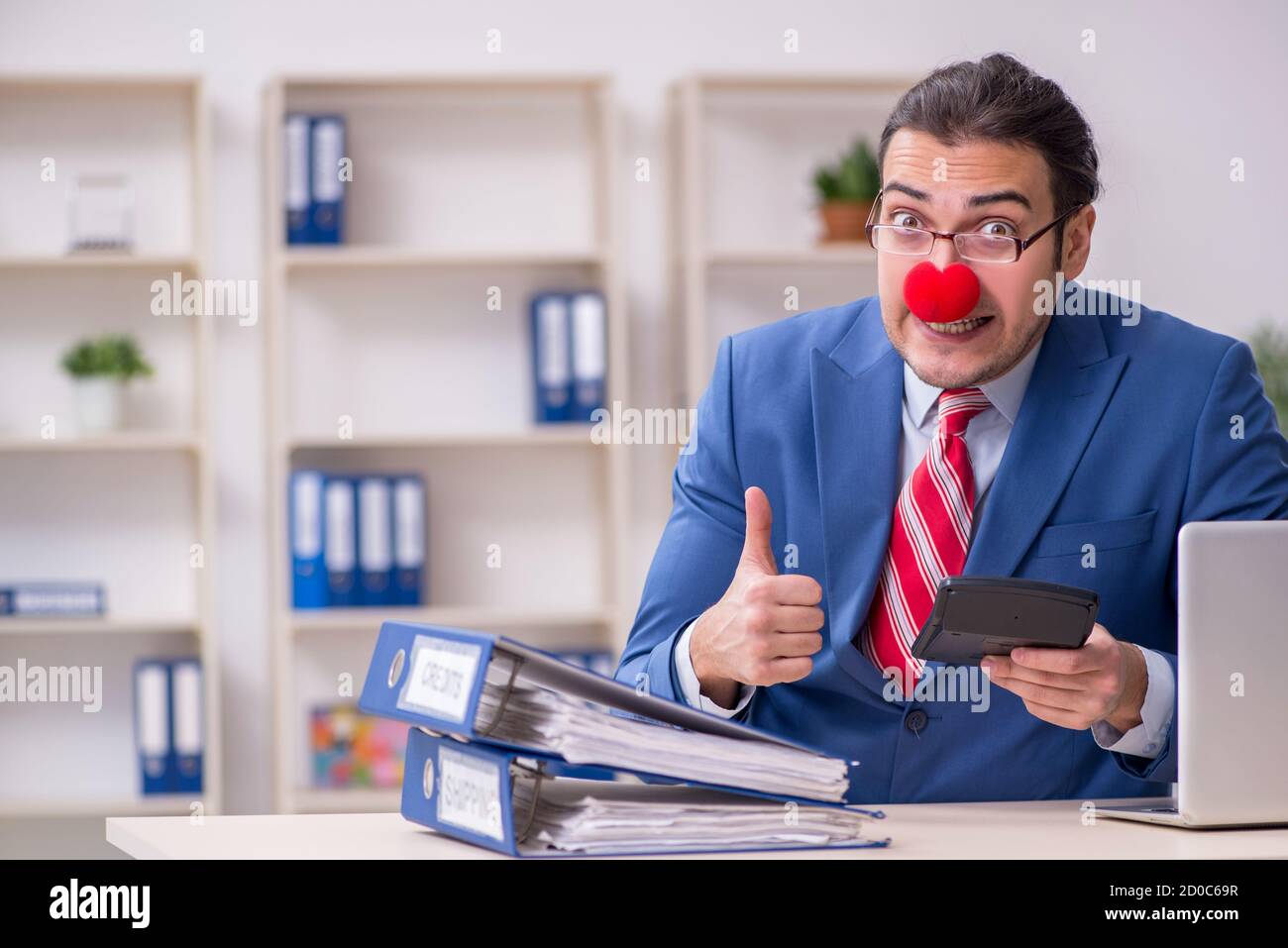 Funny employee clown working in the office room Stock Photo - Alamy