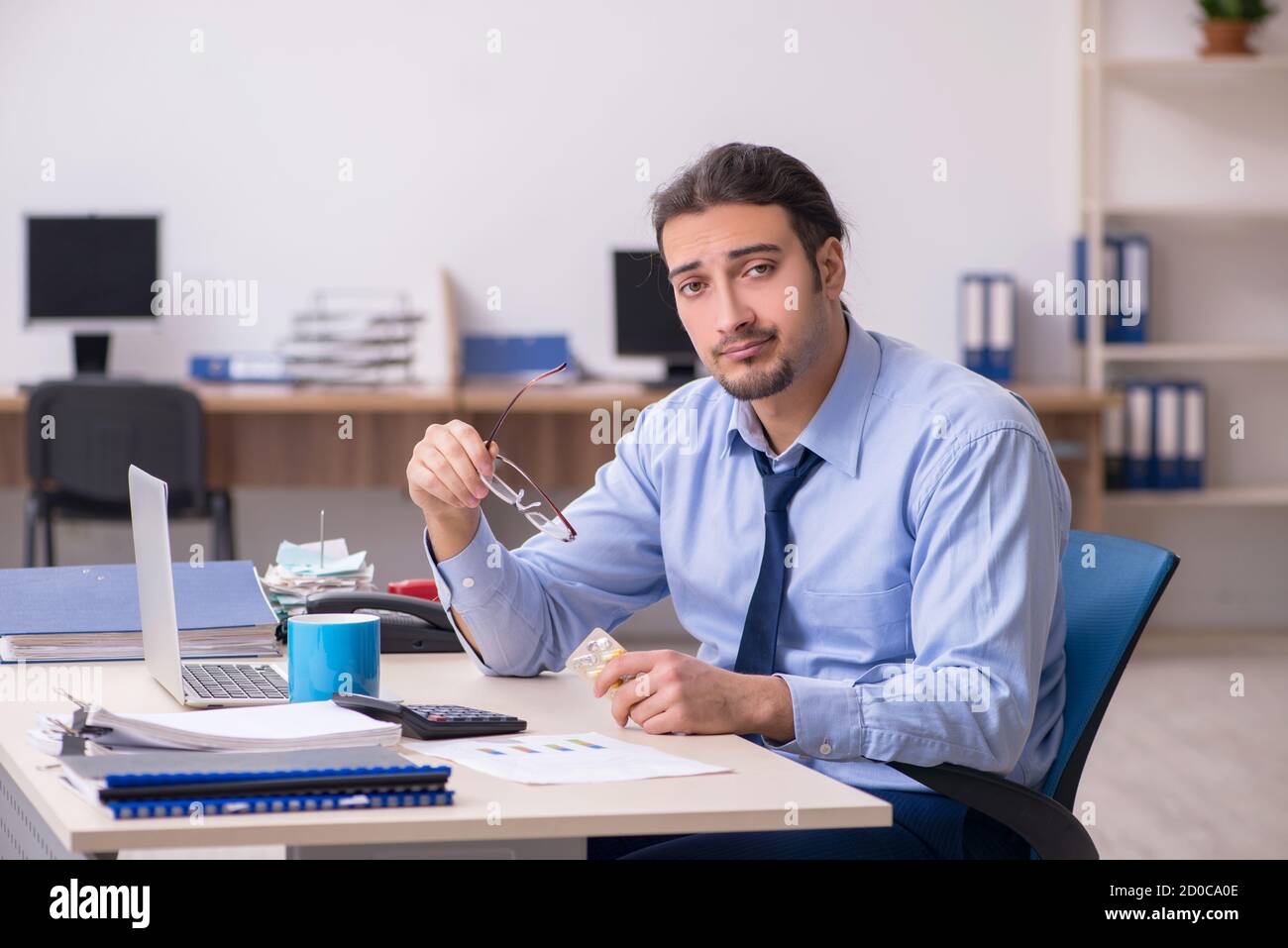 Sick male employee suffering at the workplace Stock Photo - Alamy