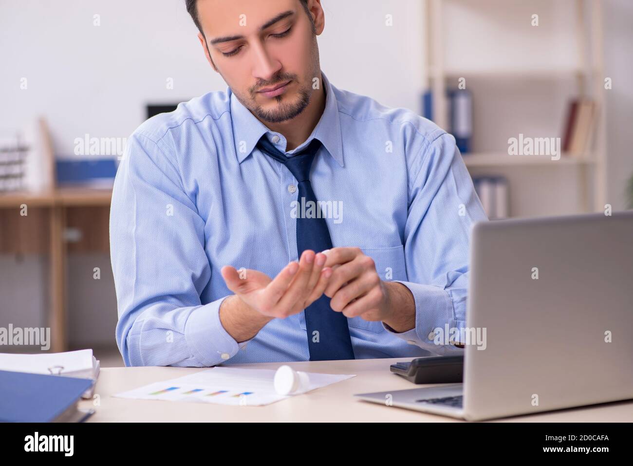 Sick male employee suffering at the workplace Stock Photo - Alamy