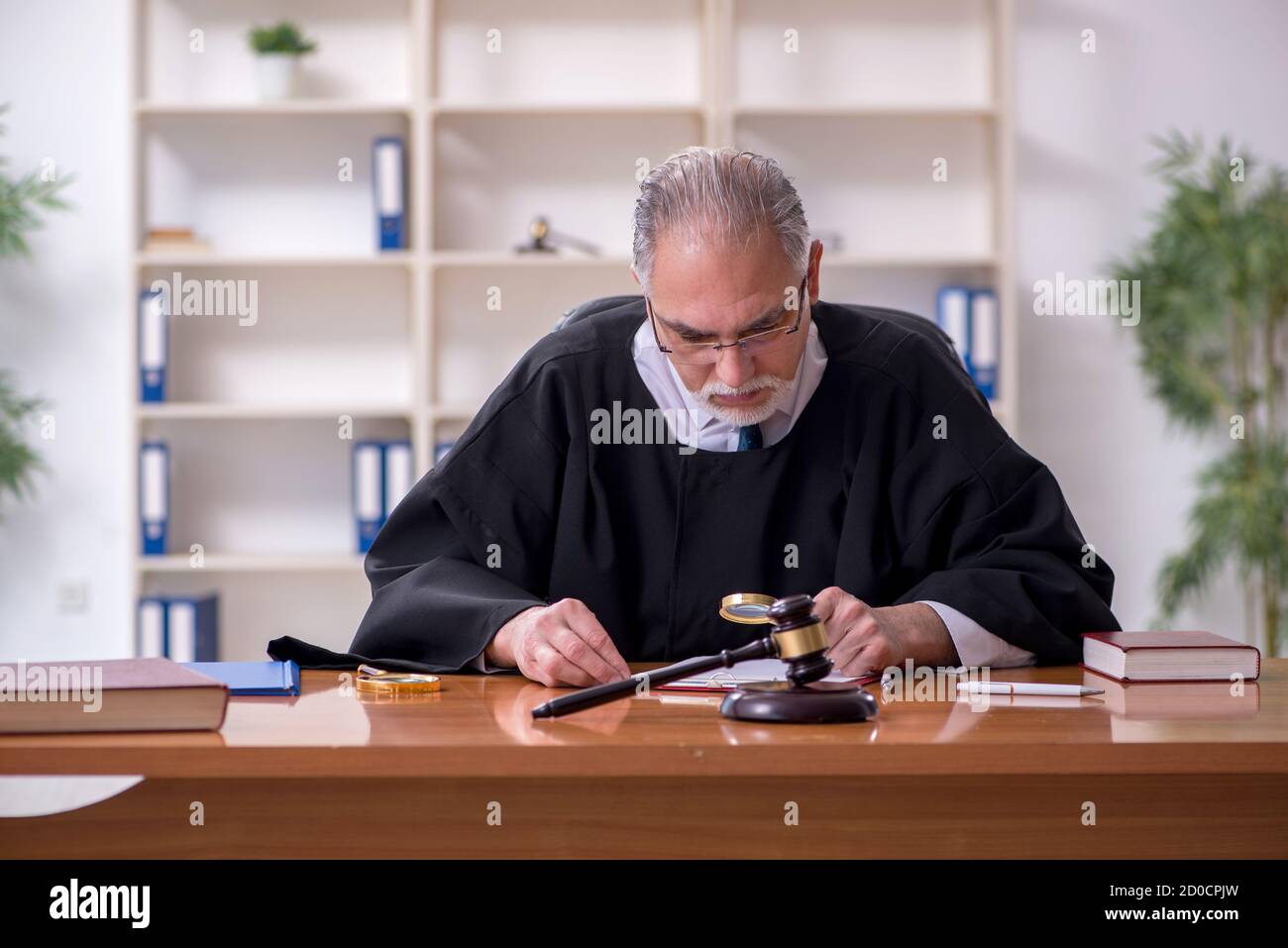 Old male judge working in the courthouse Stock Photo - Alamy