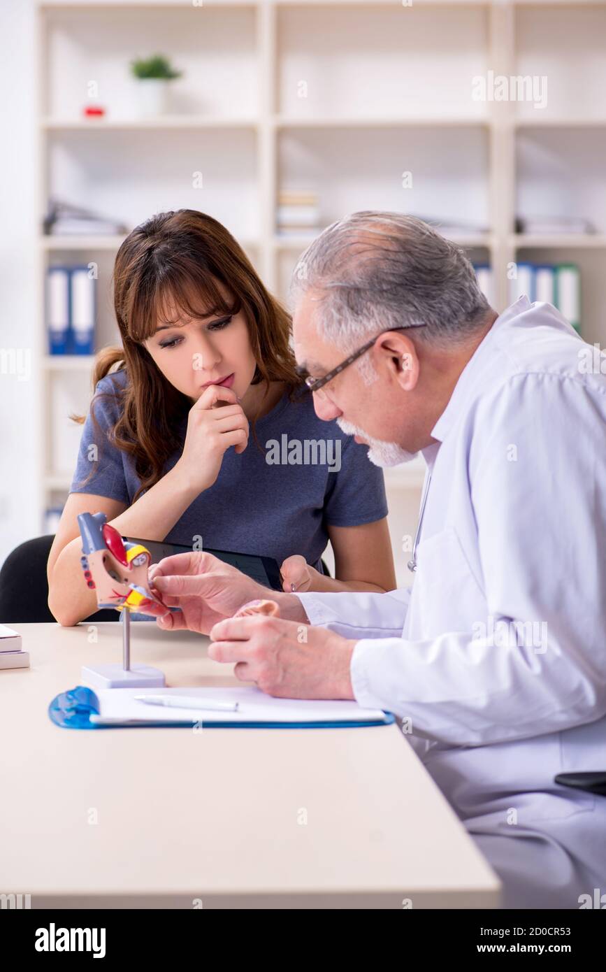 The young female patient visiting old doctor cardiologist Stock Photo ...