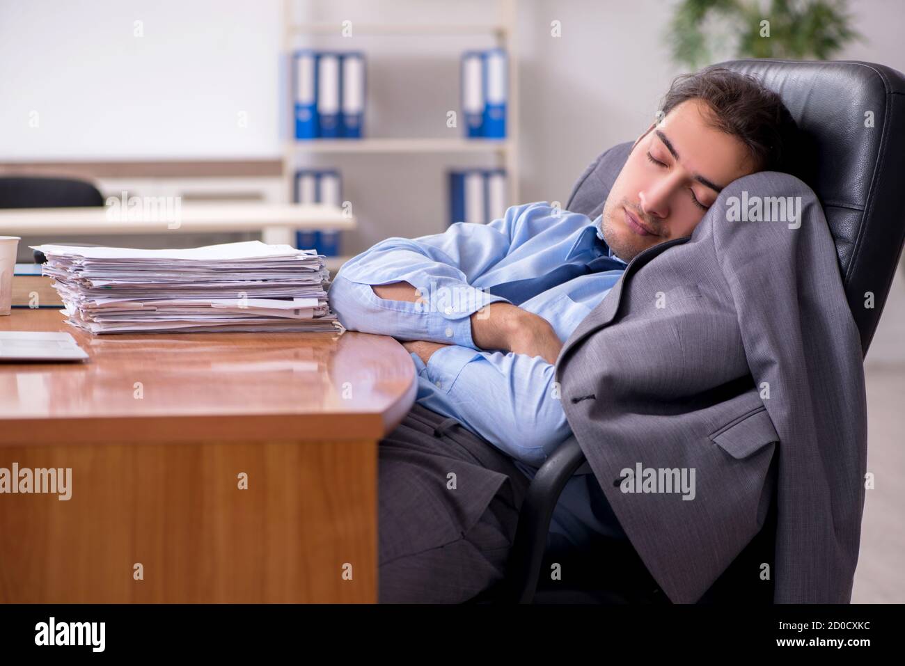 Young employee sleeping in the office Stock Photo - Alamy