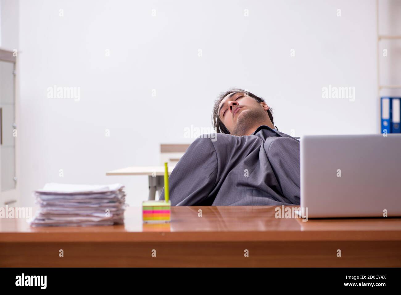 Young employee sleeping in the office Stock Photo - Alamy
