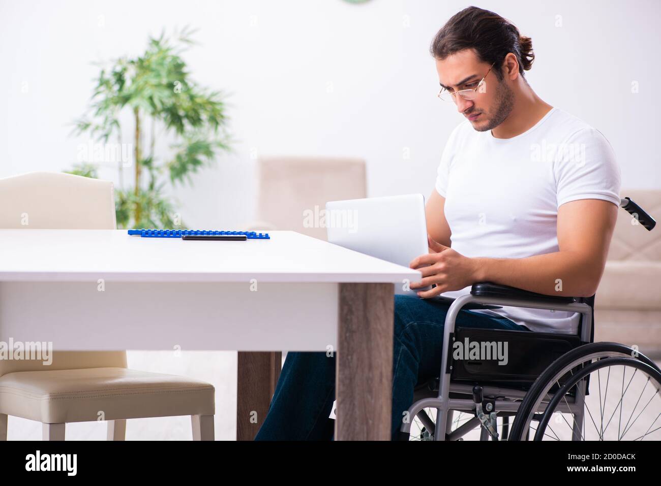 Young disabled man working from home Stock Photo - Alamy