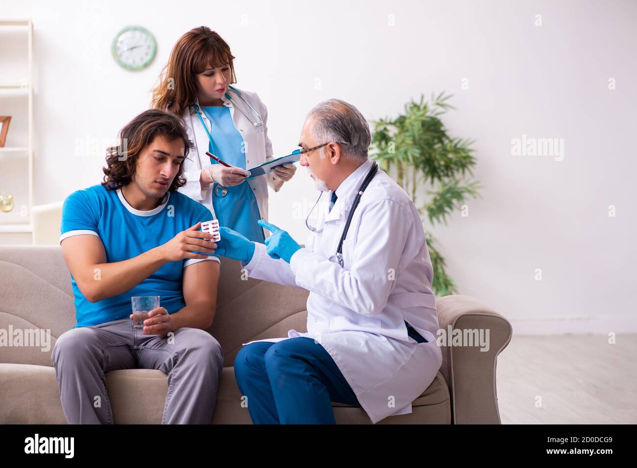 Two doctors visiting sick man at home Stock Photo - Alamy