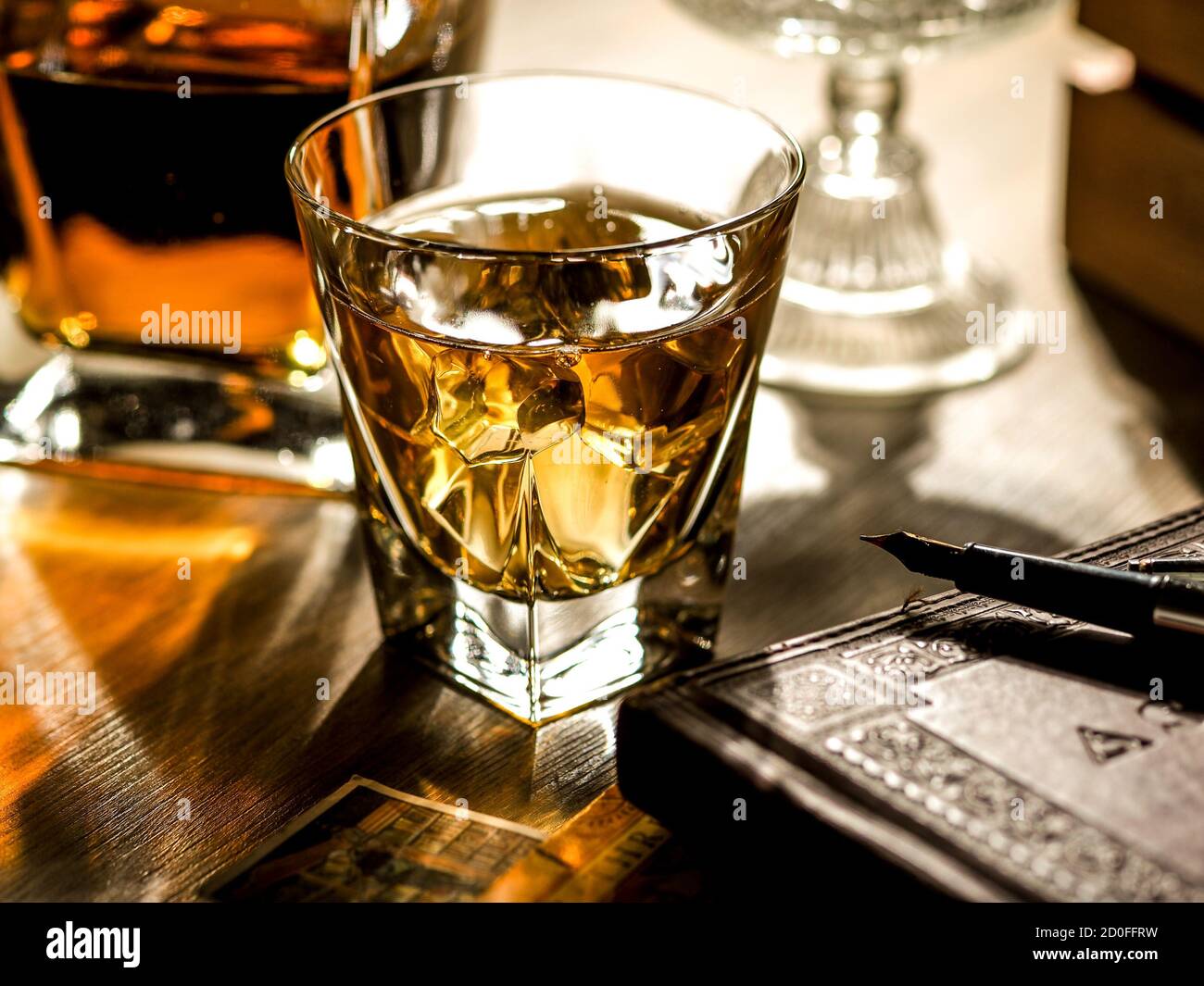 Glass of whisky, books and diary late at night Stock Photo - Alamy