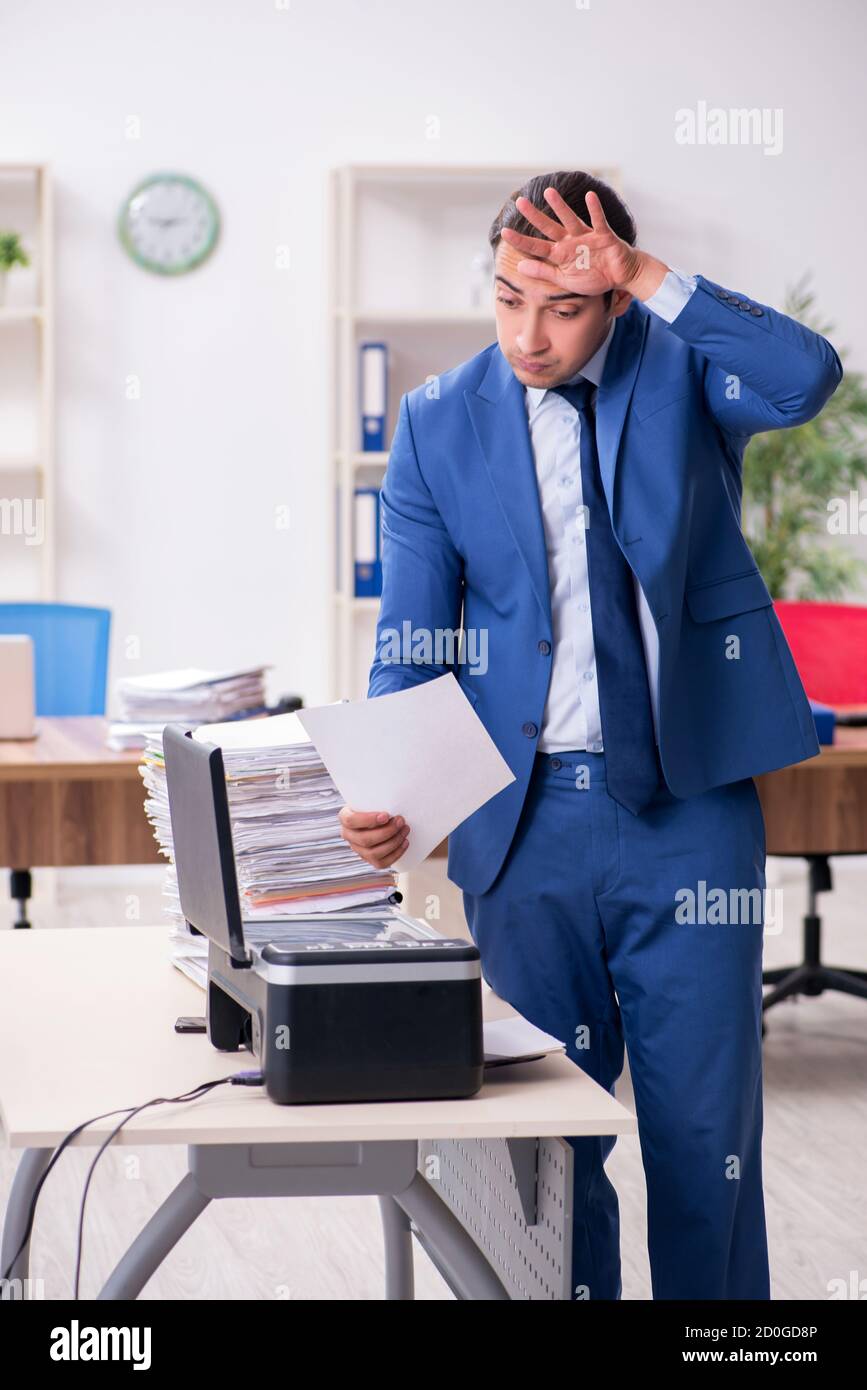 Young employee making copies at copying machine Stock Photo - Alamy