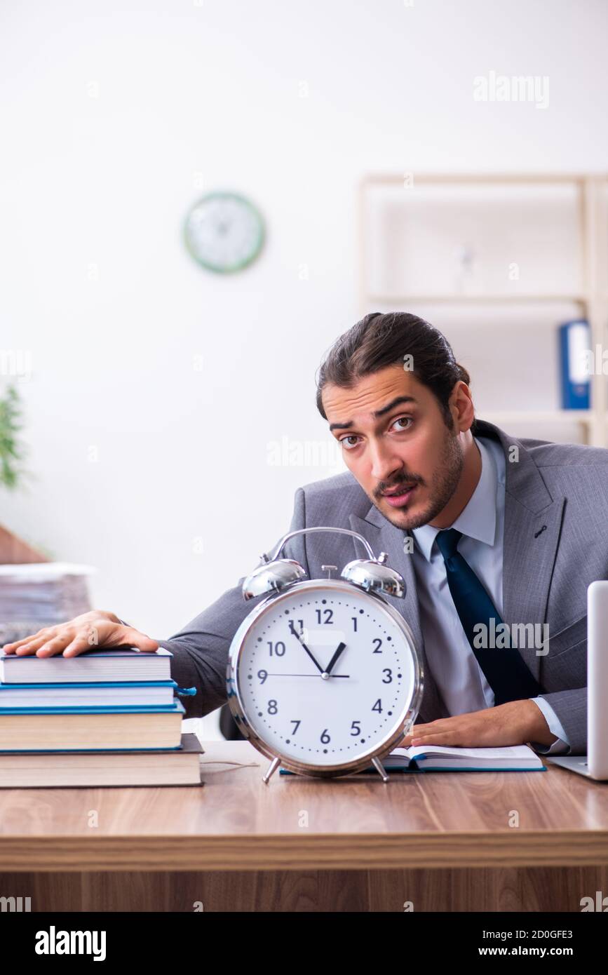 Young businessman reading books at workplace Stock Photo - Alamy