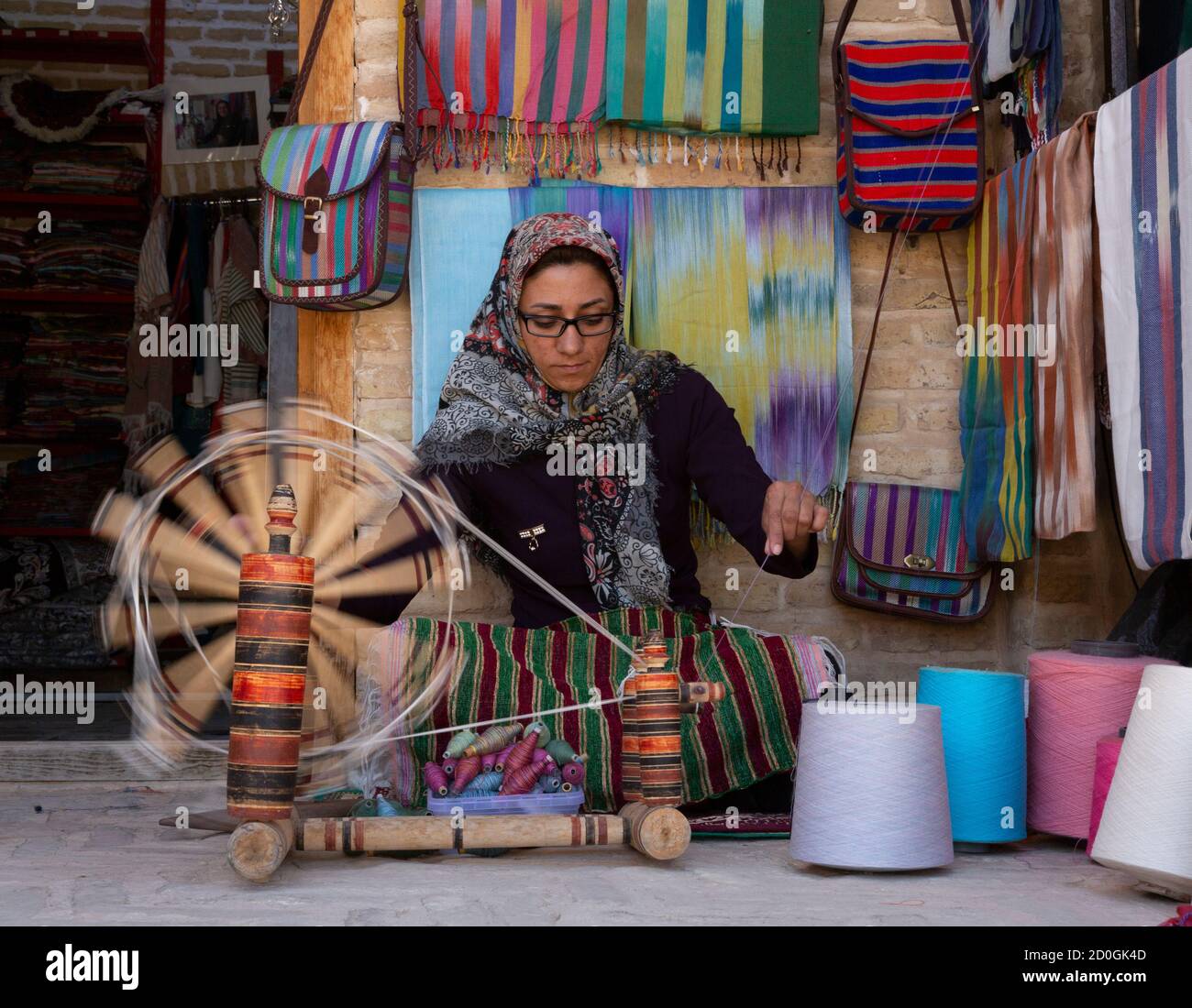 Isfahan, Iran - 2019-04-12 - Woman spins yarn on a manual spinner Stock ...