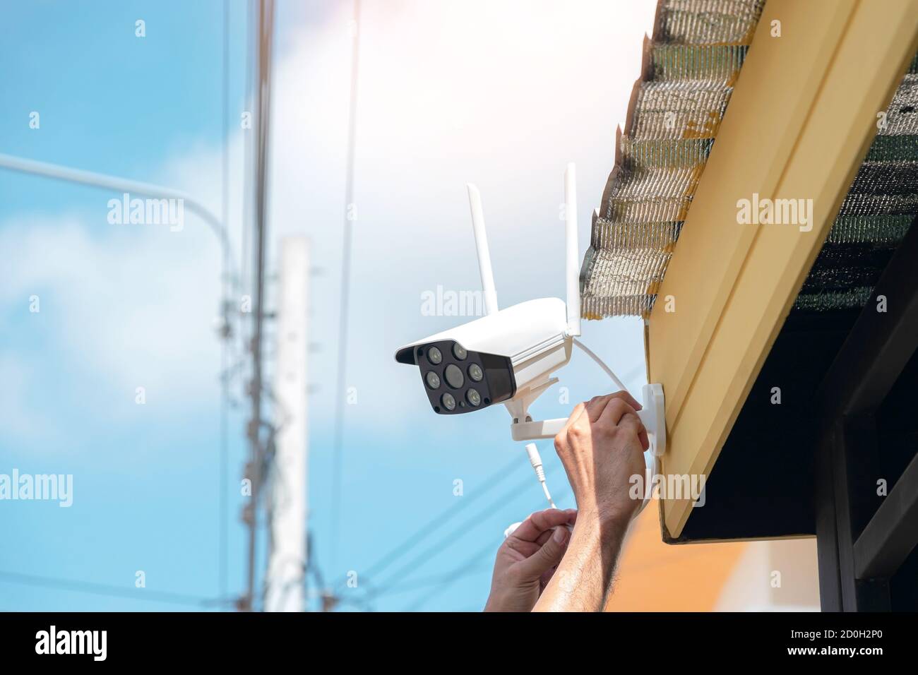 Technicians are installing a wireless CCTV camera on the front of the ...