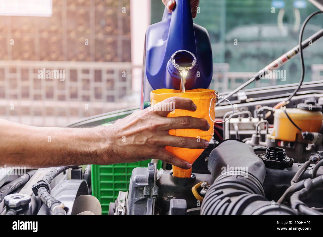 Car mechanic is adding oil to the engine, Automotive industry and ...