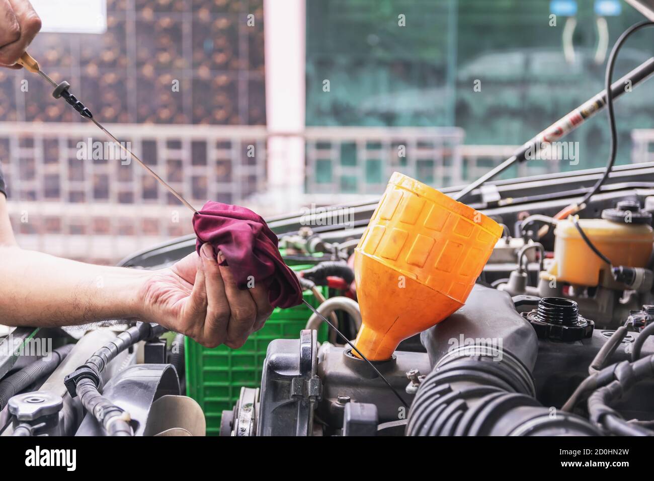 Cars mechanic is checking the level of engine oil from the engine oil ...