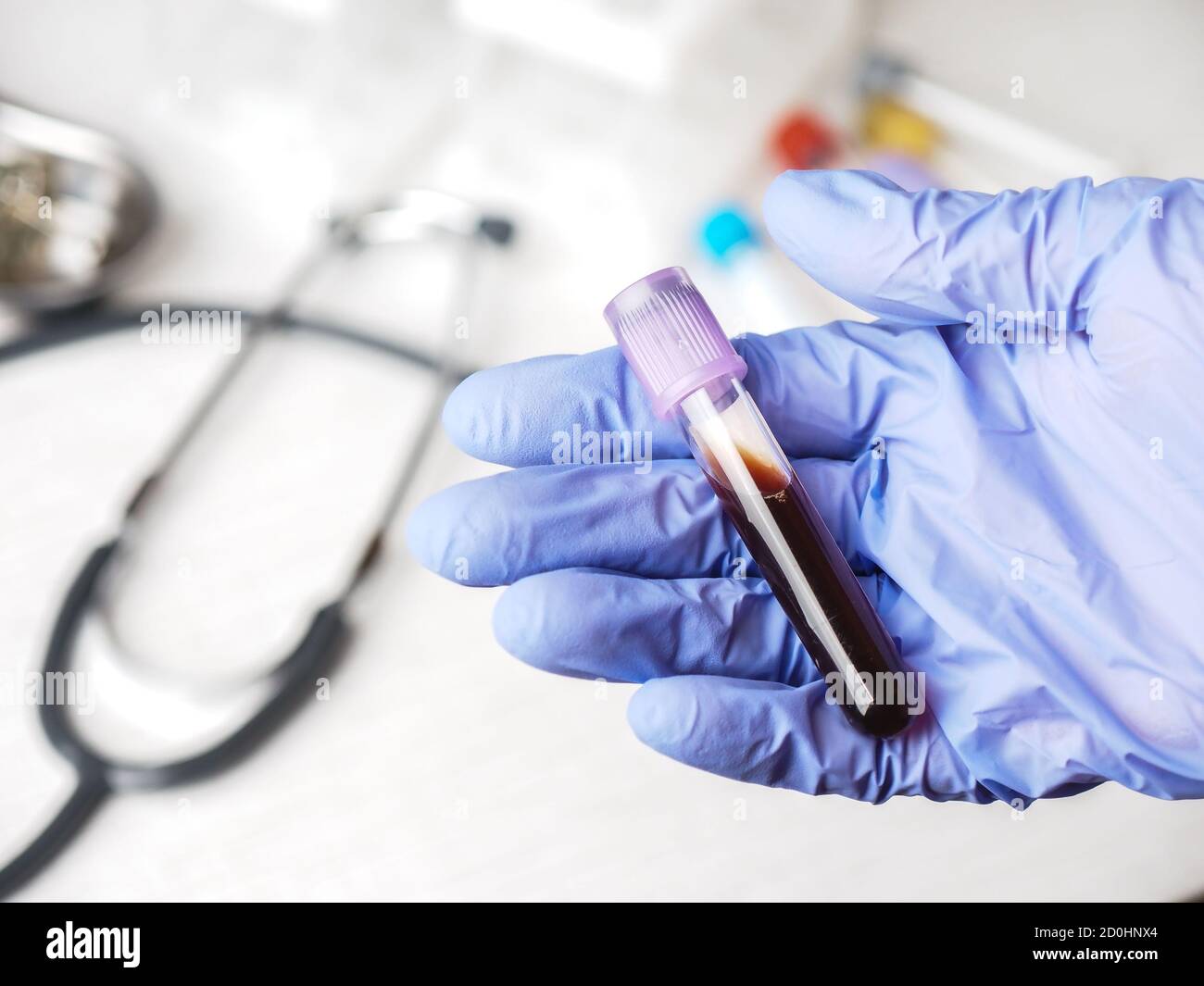 Hand in blue medical glove holding a blood test tube Stock Photo - Alamy