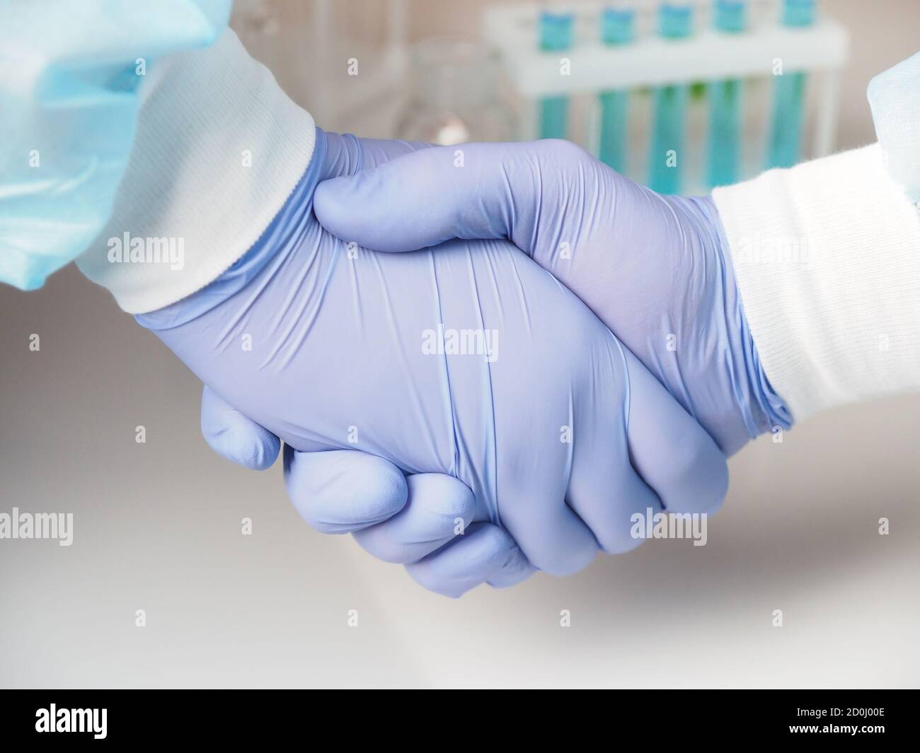 Two hands wearing medical gloves in a handshake Stock Photo - Alamy