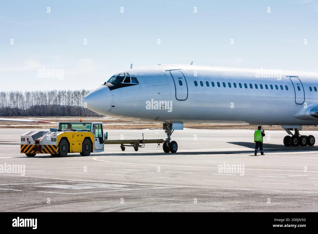 The tractor is towing the passenger airplane Stock Photo - Alamy