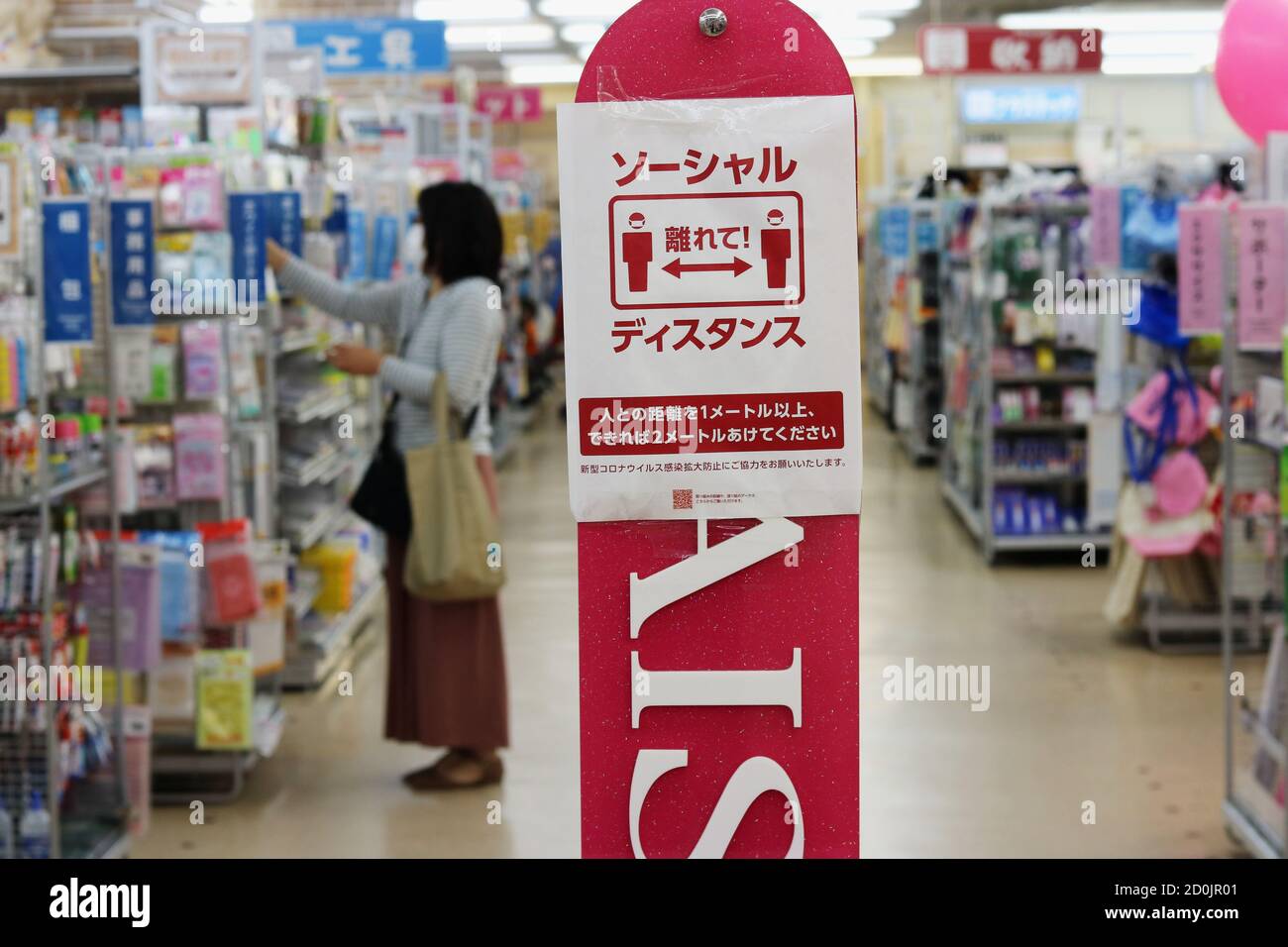 Interior of a Daiso store with a sign asking customers to practice ...